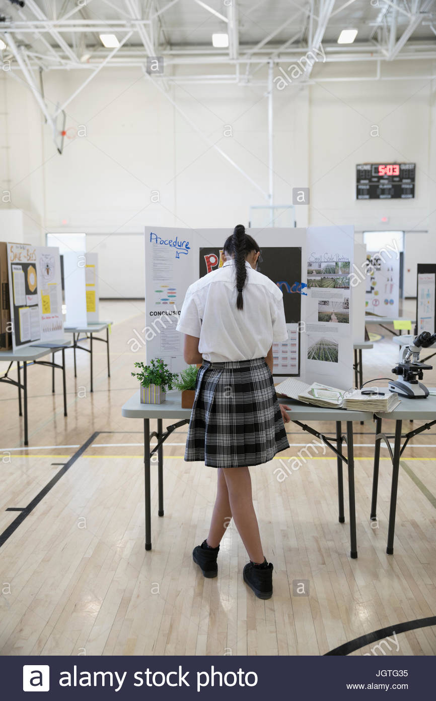 Girl middle school student viewing science project at science fair ...