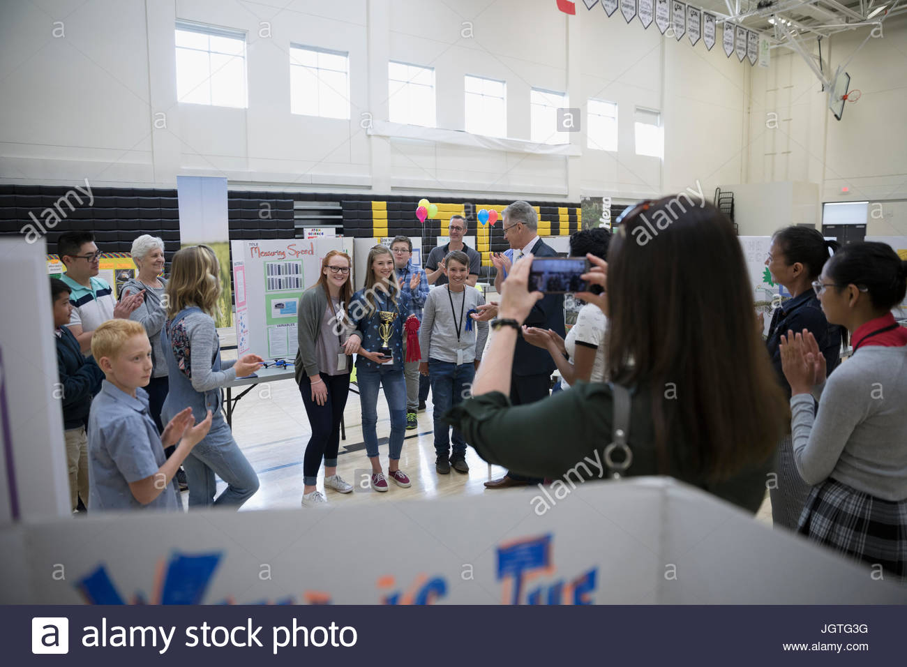 Science teacher awarding middle school students at science fair Stock ...