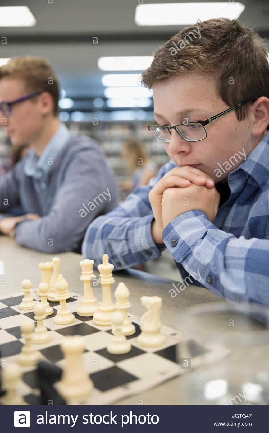 Focused male middle school student playing chess in chess club Stock ...