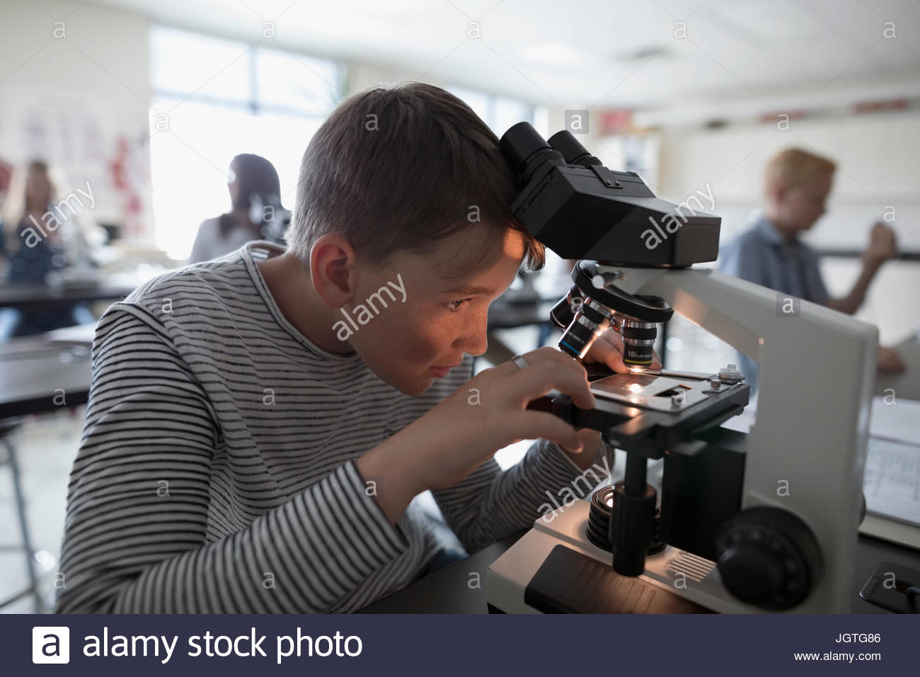 Boy middle school student using microscope, conducting scientific ...