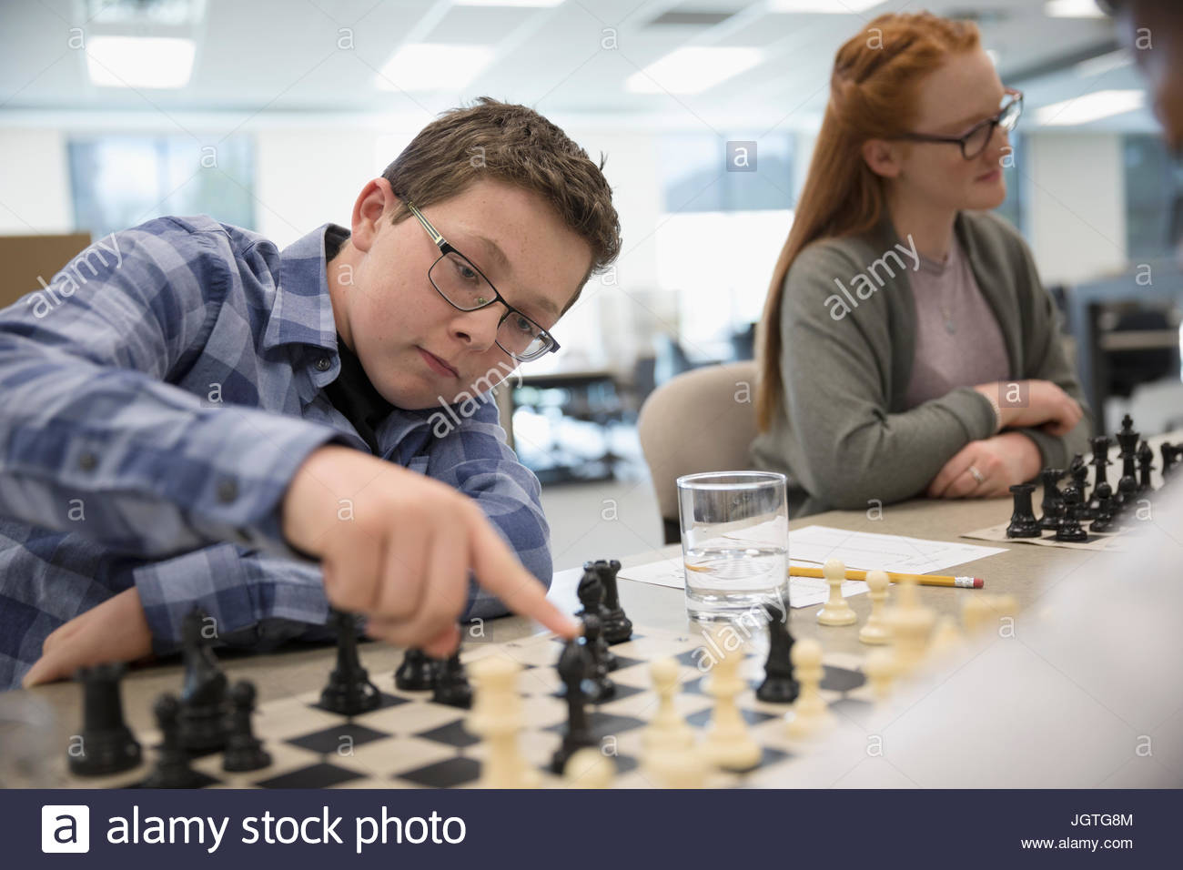 Focused boy middle school student playing chess in chess club Stock ...