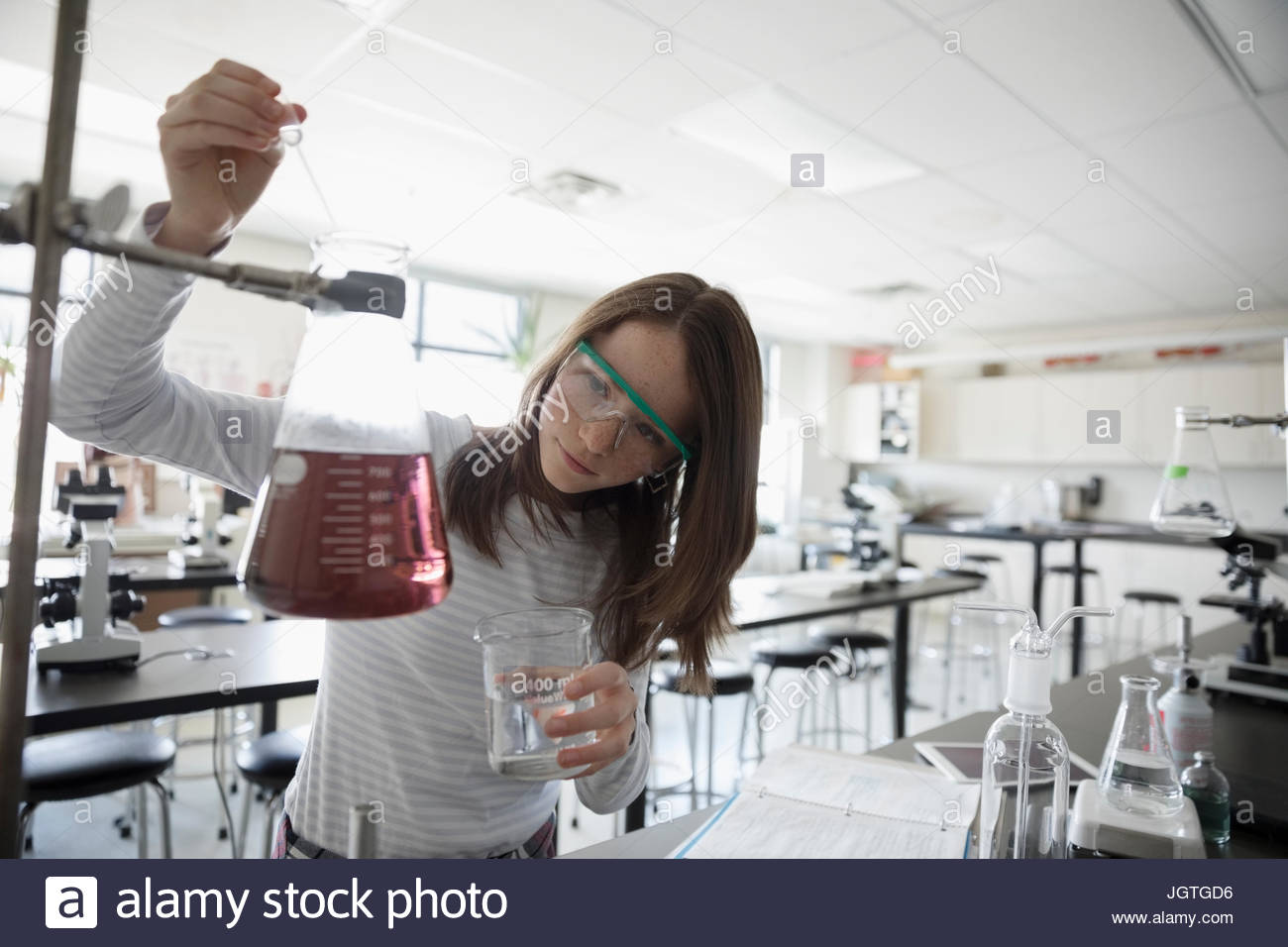 School girl conducting experiment in hi-res stock photography and ...