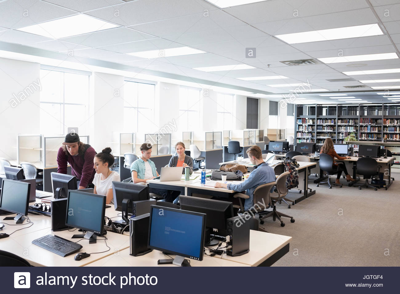 Boy and girl in a library and computer hi-res stock photography and ...