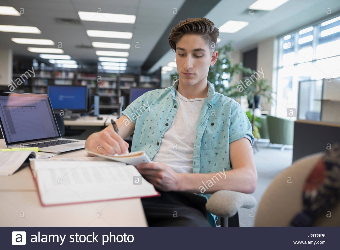 Male college student studying in library Stock Photo - Alamy