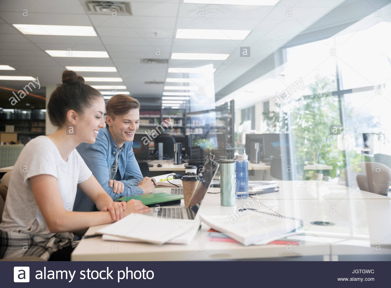 Studying in library laptop book hi-res stock photography and images - Alamy