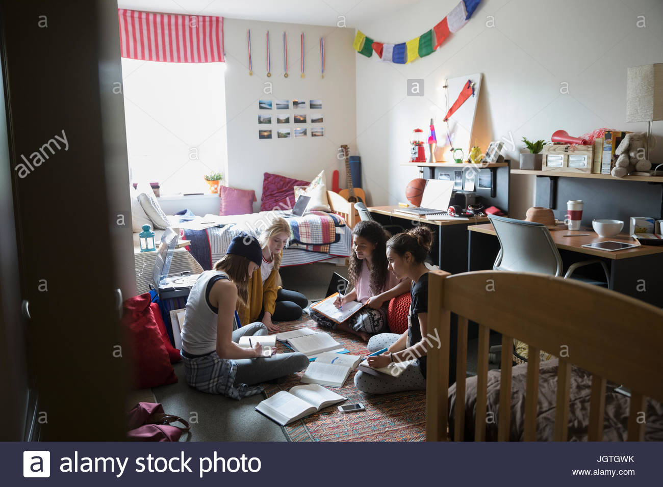 Female college students studying on floor in dorm room Stock Photo - Alamy