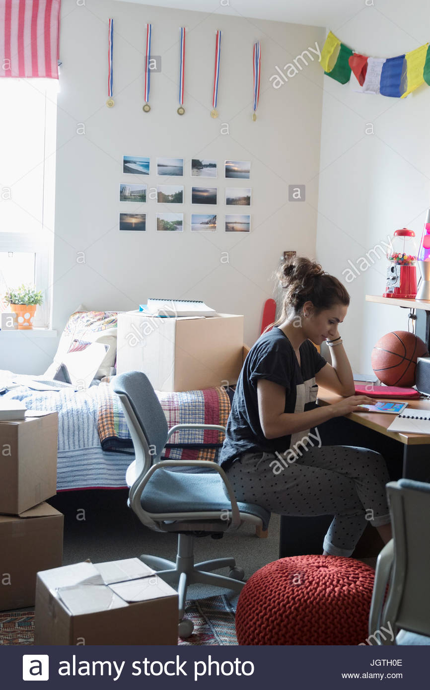 Female colleague student using digital tablet, studying in dorm room ...