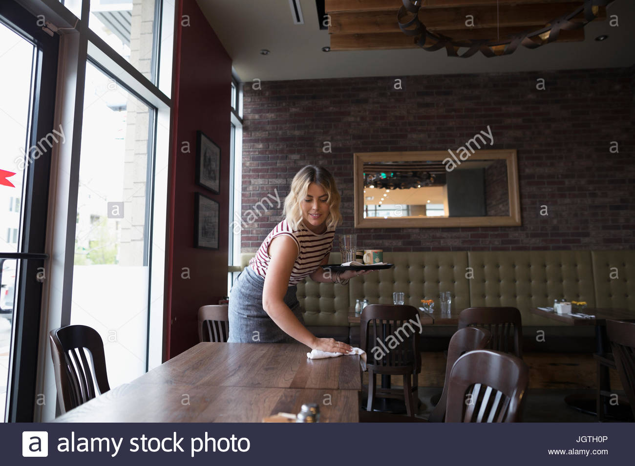 Young waitress wiping table hi-res stock photography and images - Alamy
