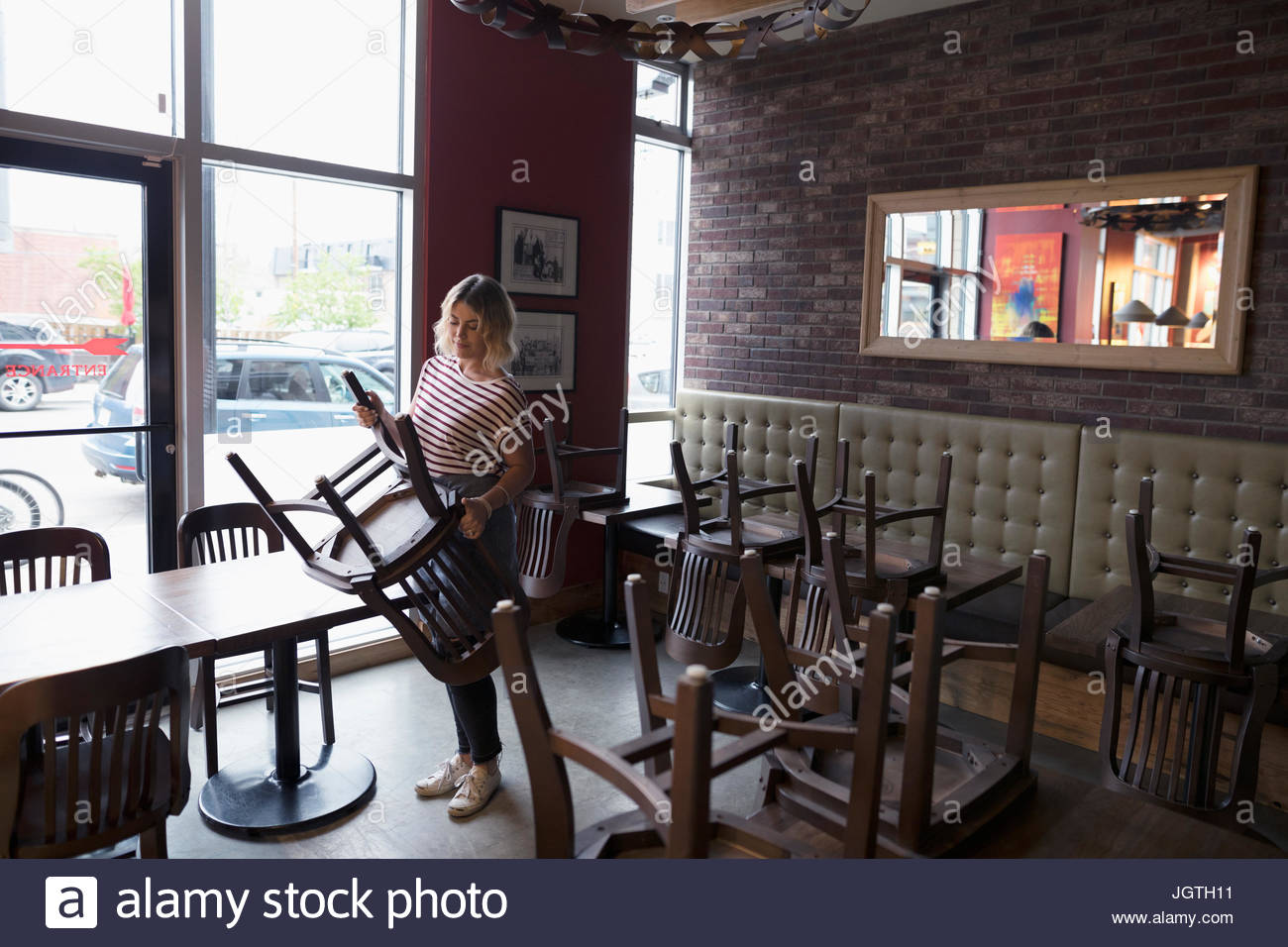 Waitress turning chairs onto tables, closing at diner Stock Photo - Alamy