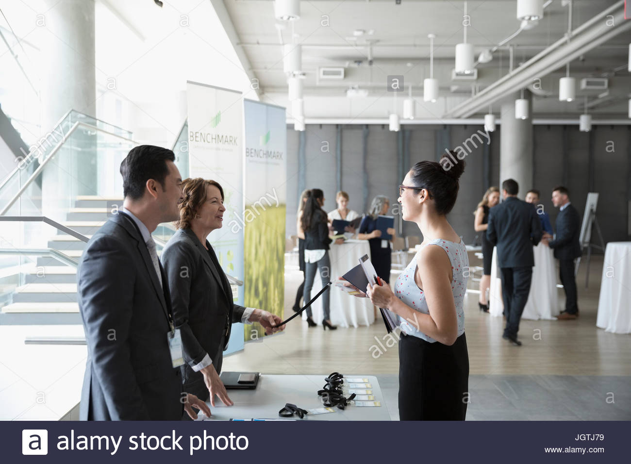 Businesswoman arriving at conference check-in table Stock Photo - Alamy