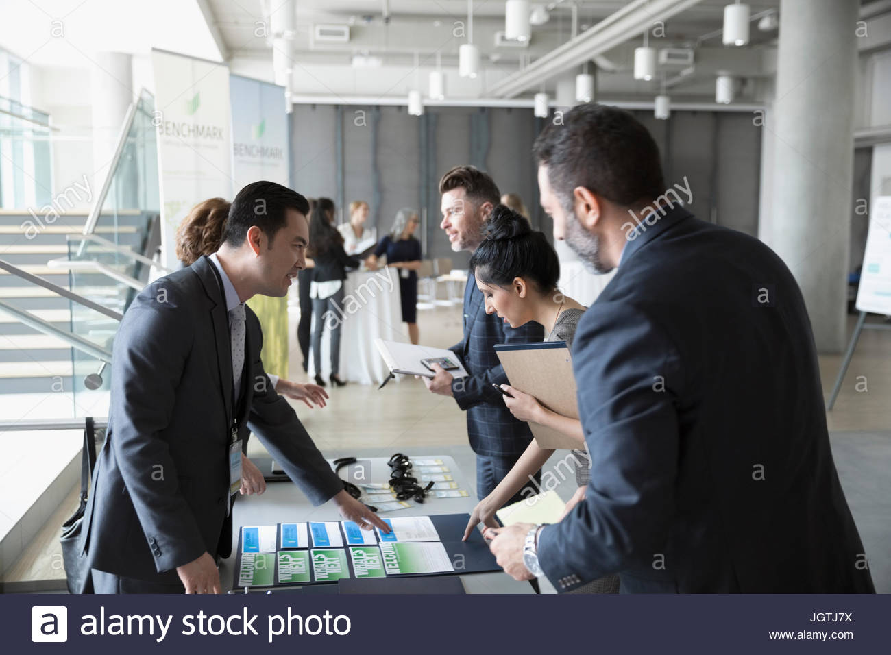Business people arriving at conference check-in table Stock Photo - Alamy