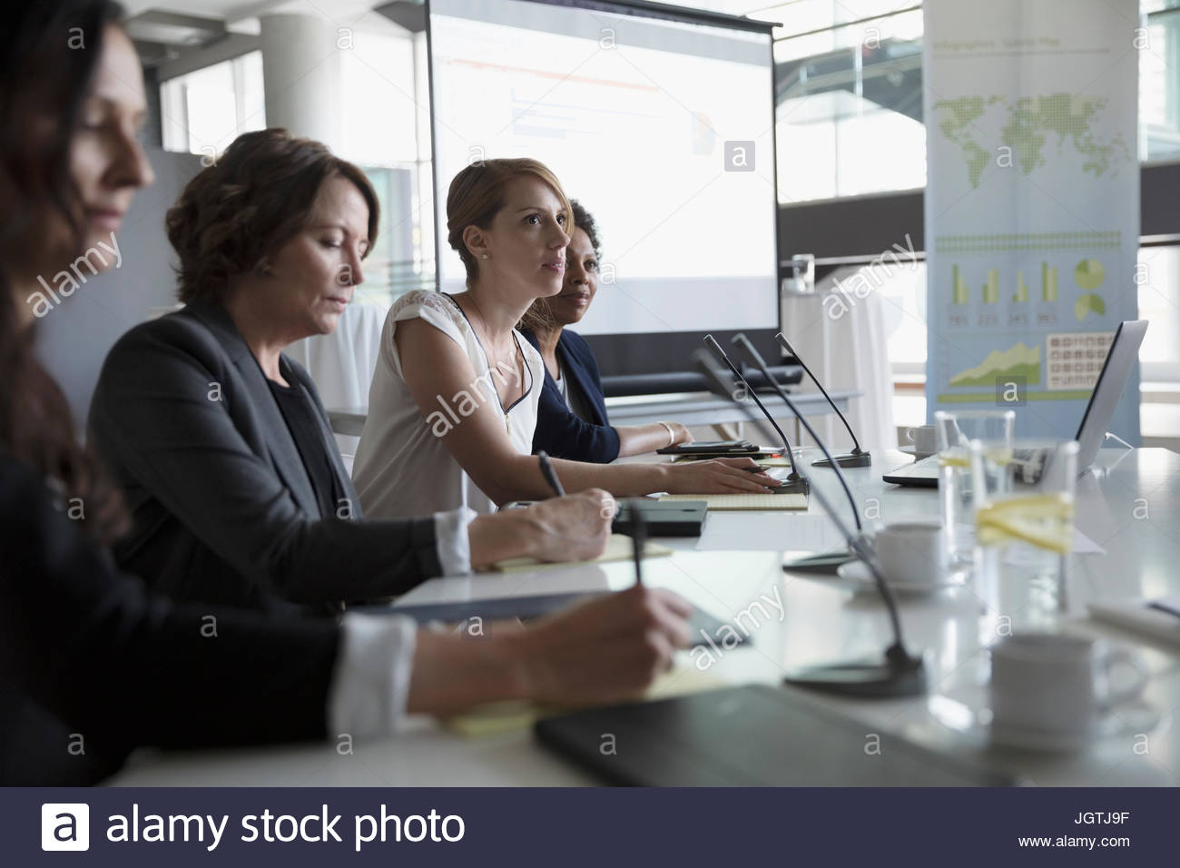 Serious businesswomen listening on conference panel Stock Photo - Alamy