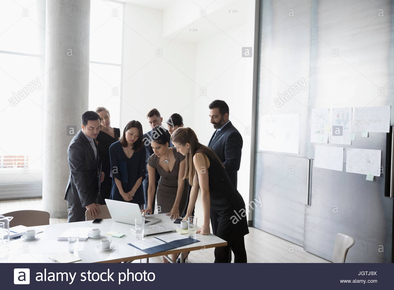 Business people working around laptop in conference room meeting Stock ...