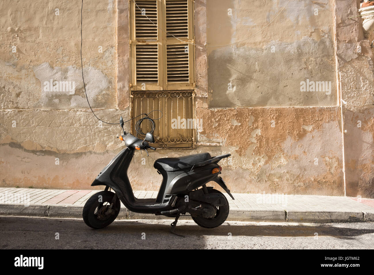 A motor scooter or motorbike parked in a street in Valetta Malta Stock ...