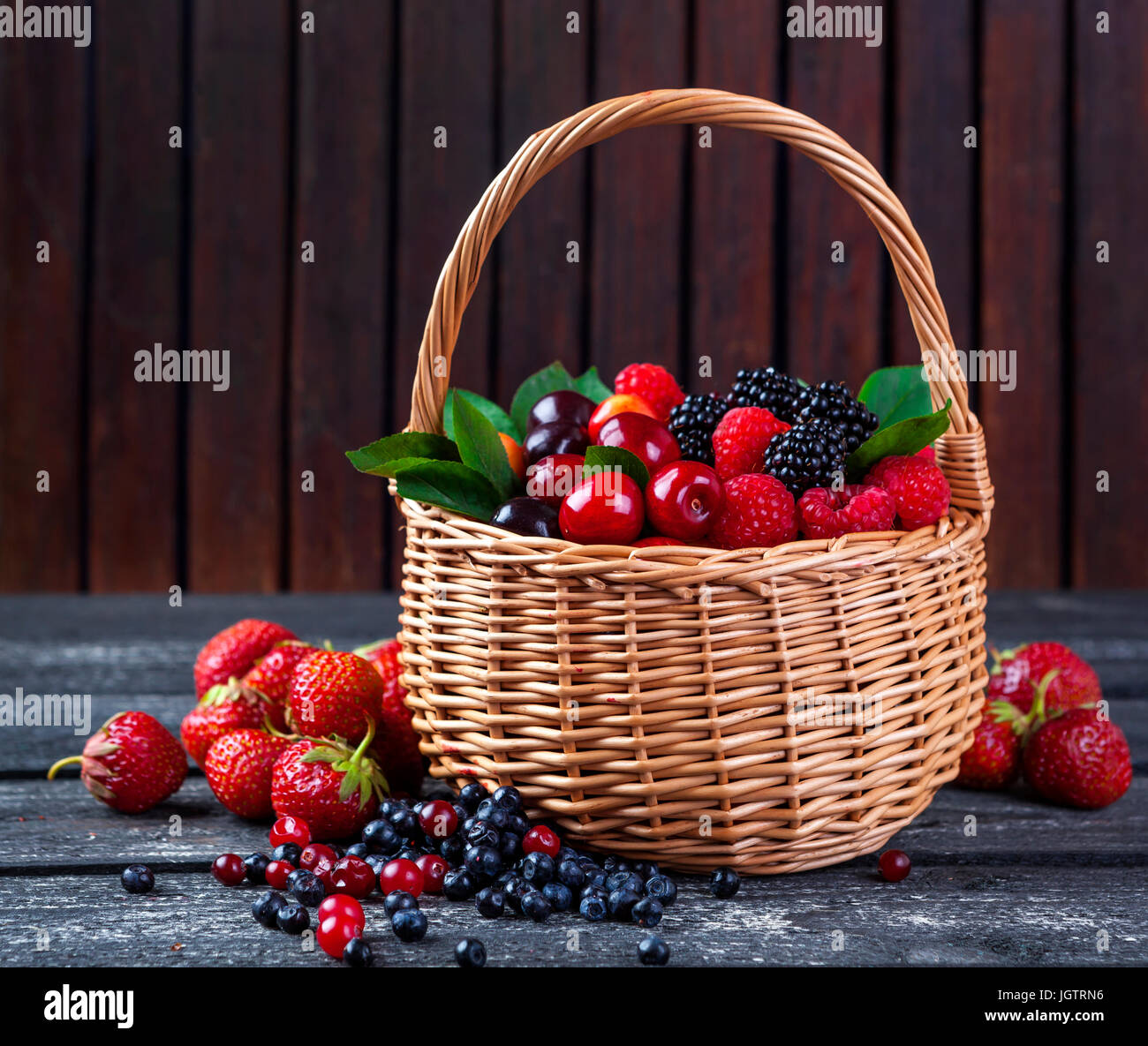 Berries mix in basket on rustic wooden background Stock Photo - Alamy
