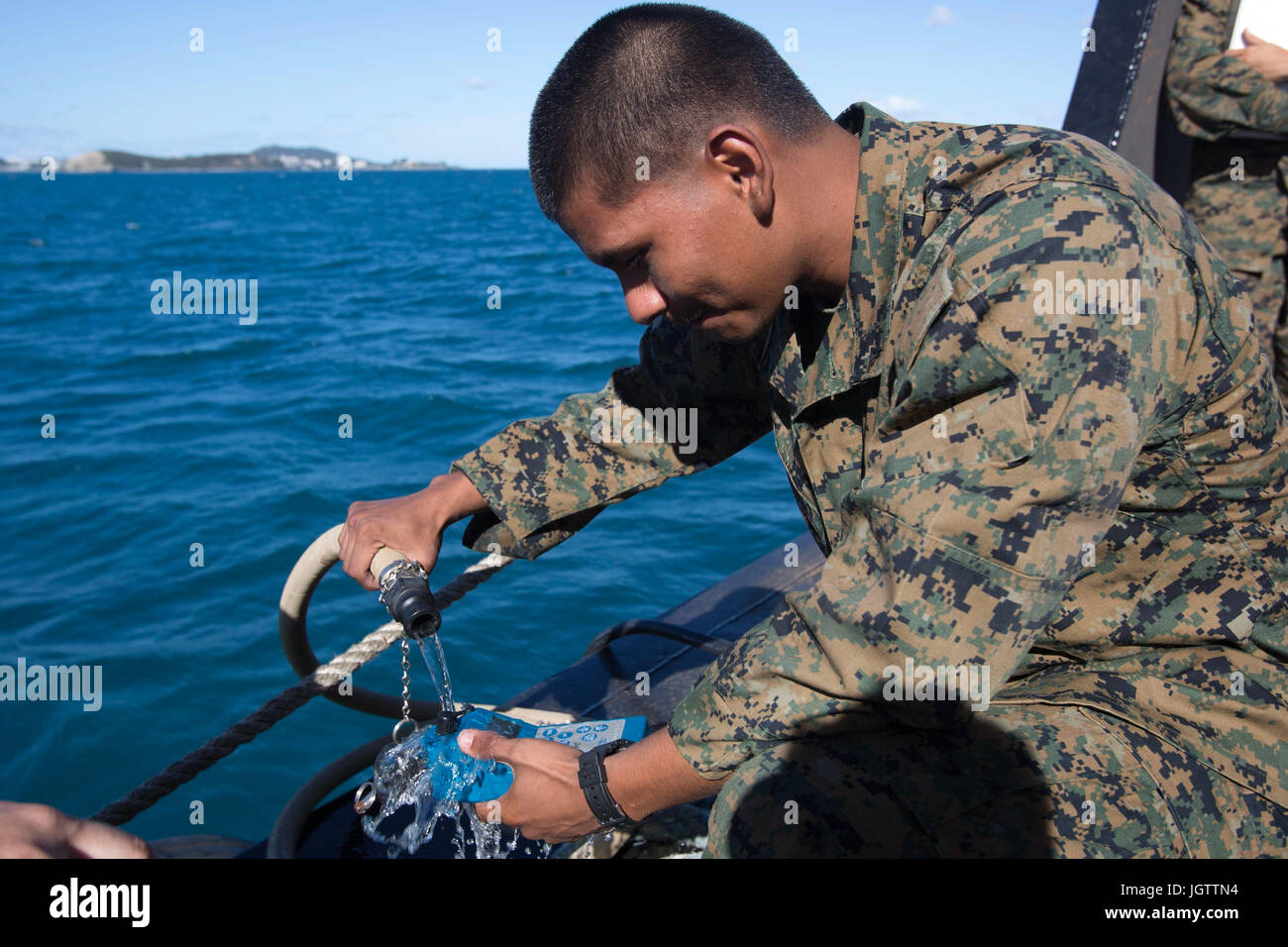 USNS SACAGAWEA— Lance Cpl. Ivan Gallardo tests purified water from a ...