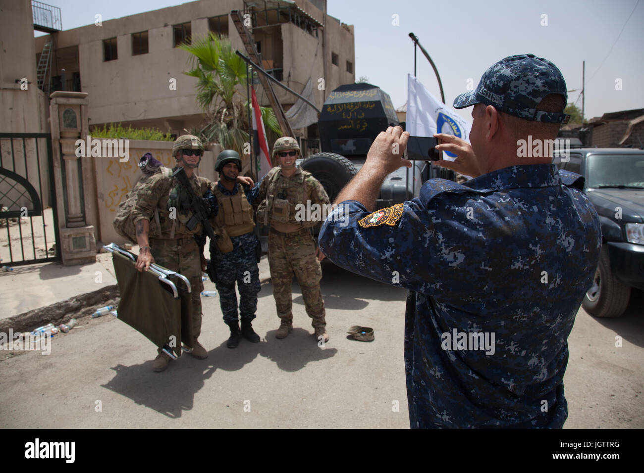 An Iraqi Federal Police member takes a photo of U.S. Army Pfc. Ty Fox ...