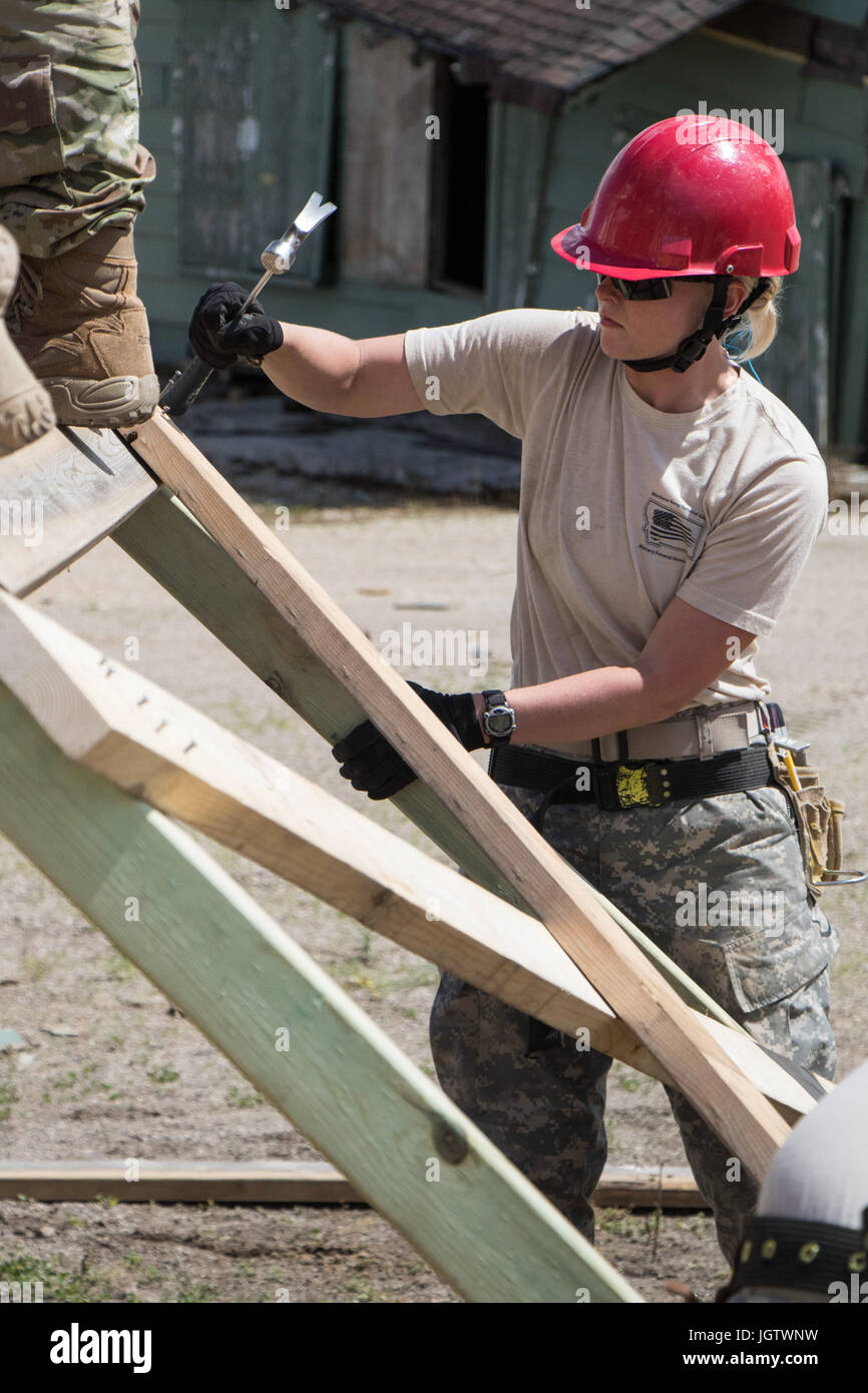 A soldier with the 1049th Firefighting Detachment, hammers nails into a ...