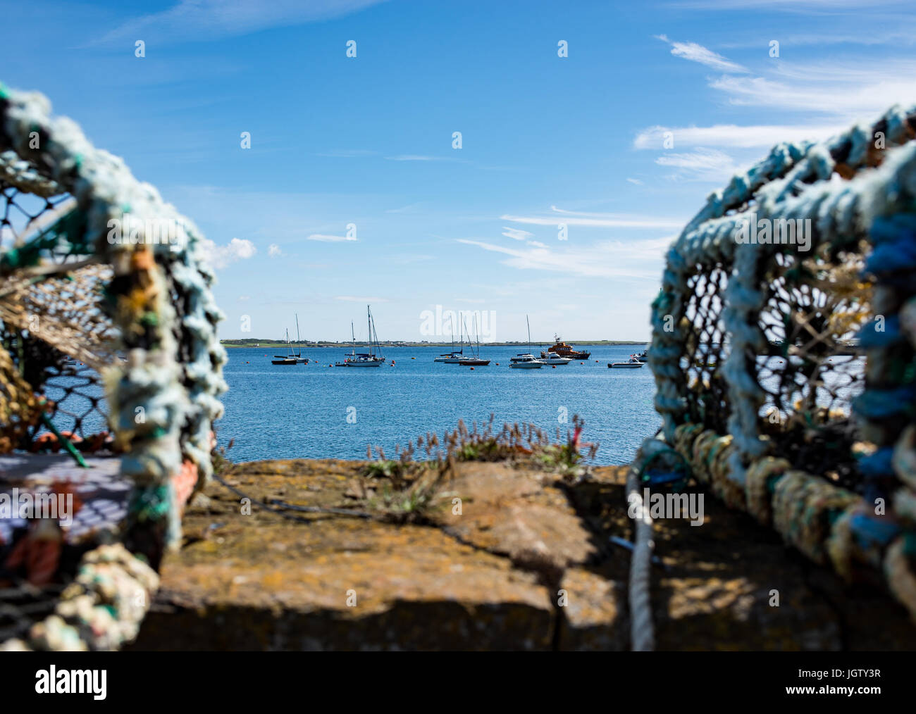 Lobster net cages in a harbour wall with view boat in the harbour Stock ...