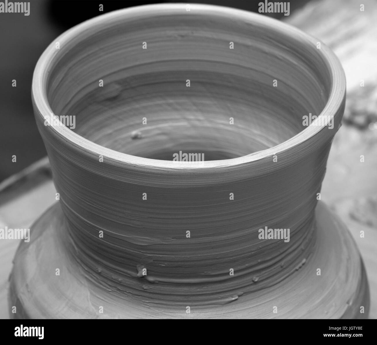 Black and white view on process of making clay vase on pottery wheel ...