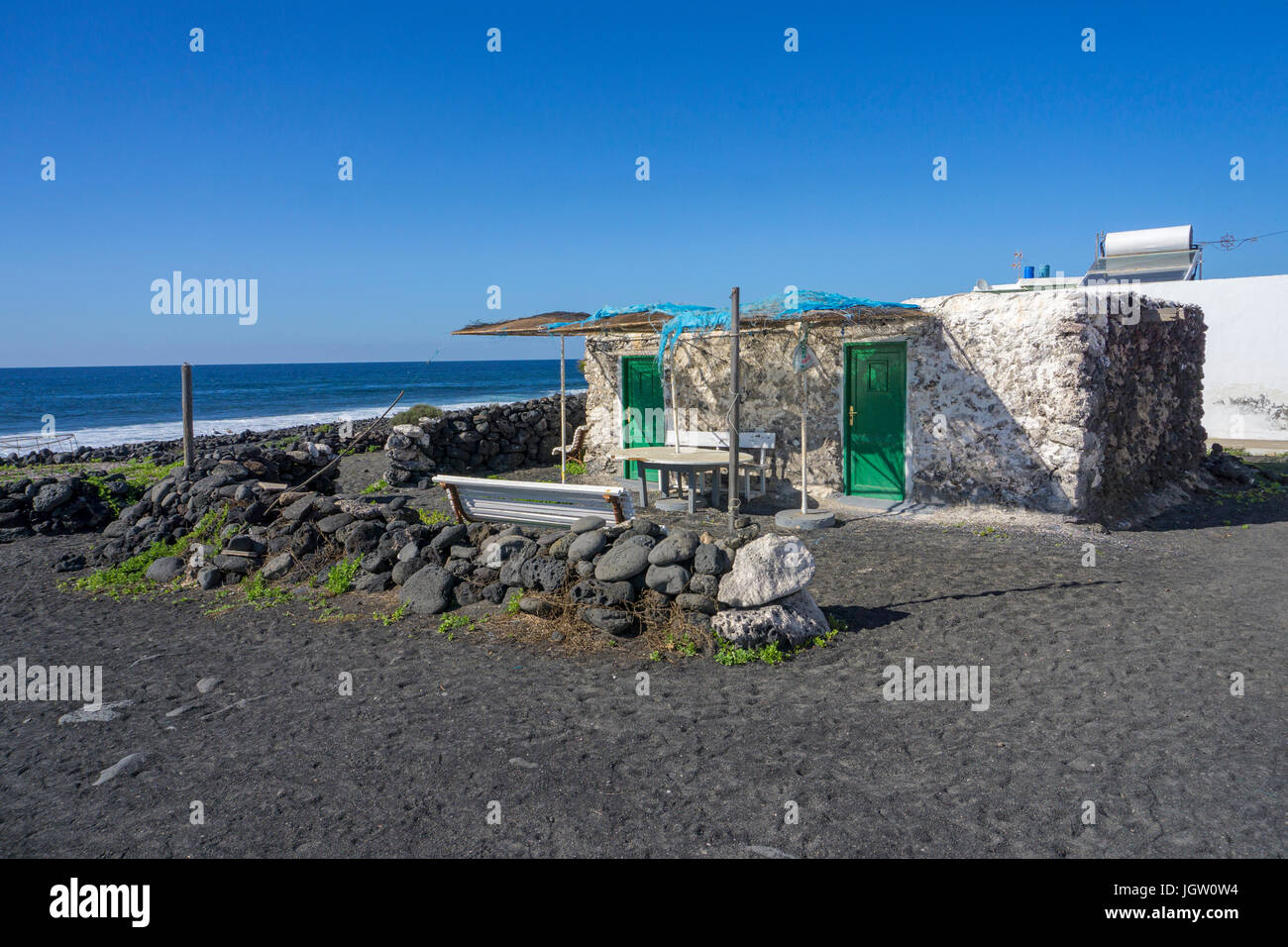 Small fishing house at the volcanic pebble beach, fishing village El ...