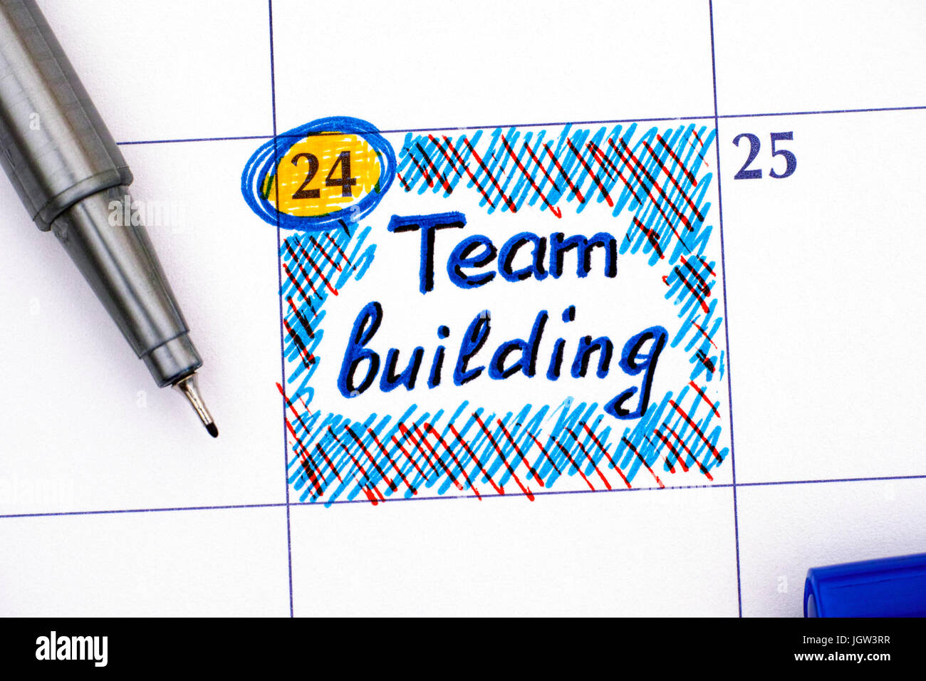 Reminder Team building in calendar with blue pen Stock Photo - Alamy