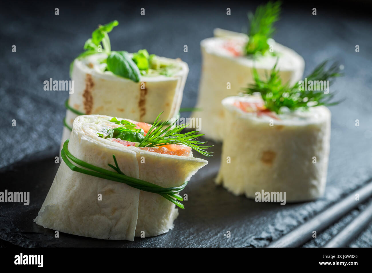 Closeup of rolls with vegetables and cheese on black rock Stock Photo ...