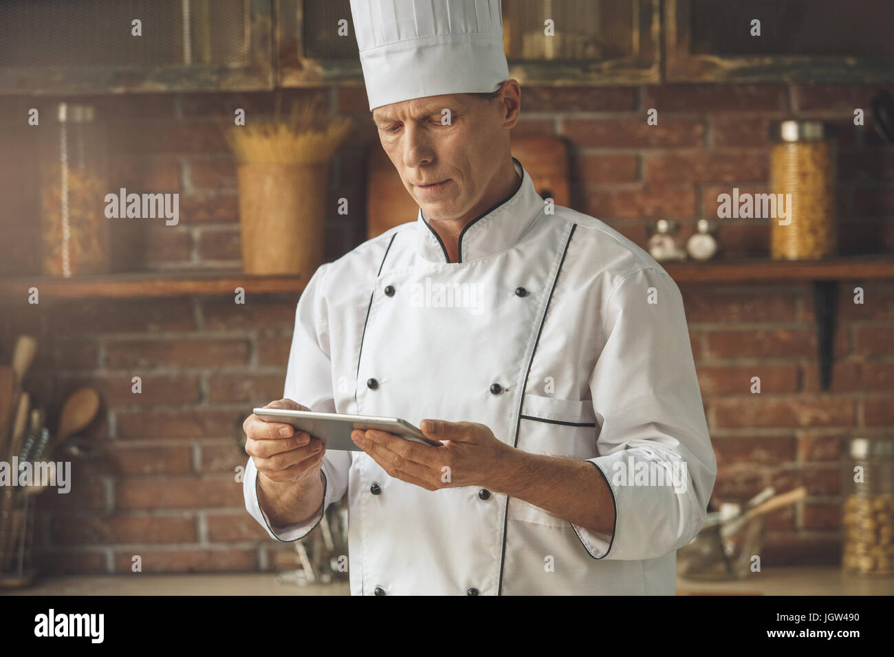 Mature man professional chef cooking meal indoors Stock Photo - Alamy