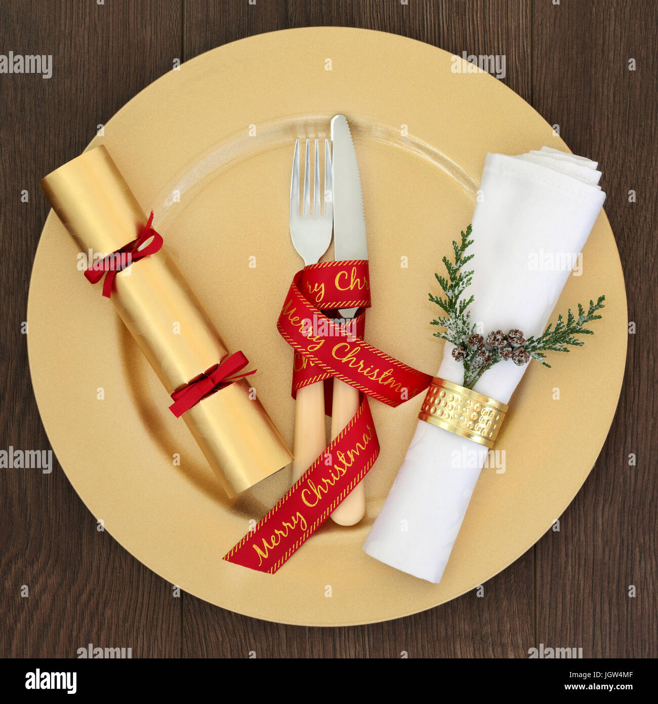 Christmas table place setting with gold dinner plate, cutlery with red ...