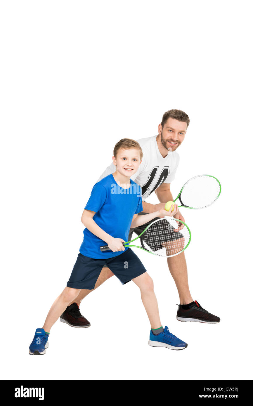 side view of active father and son with tennis racquets isolated on ...