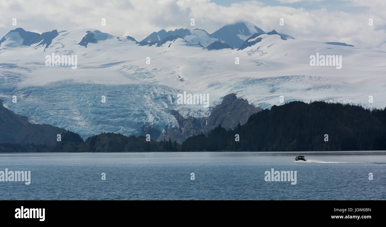 A small motor boat speeds towards a distance glacier Stock Photo - Alamy