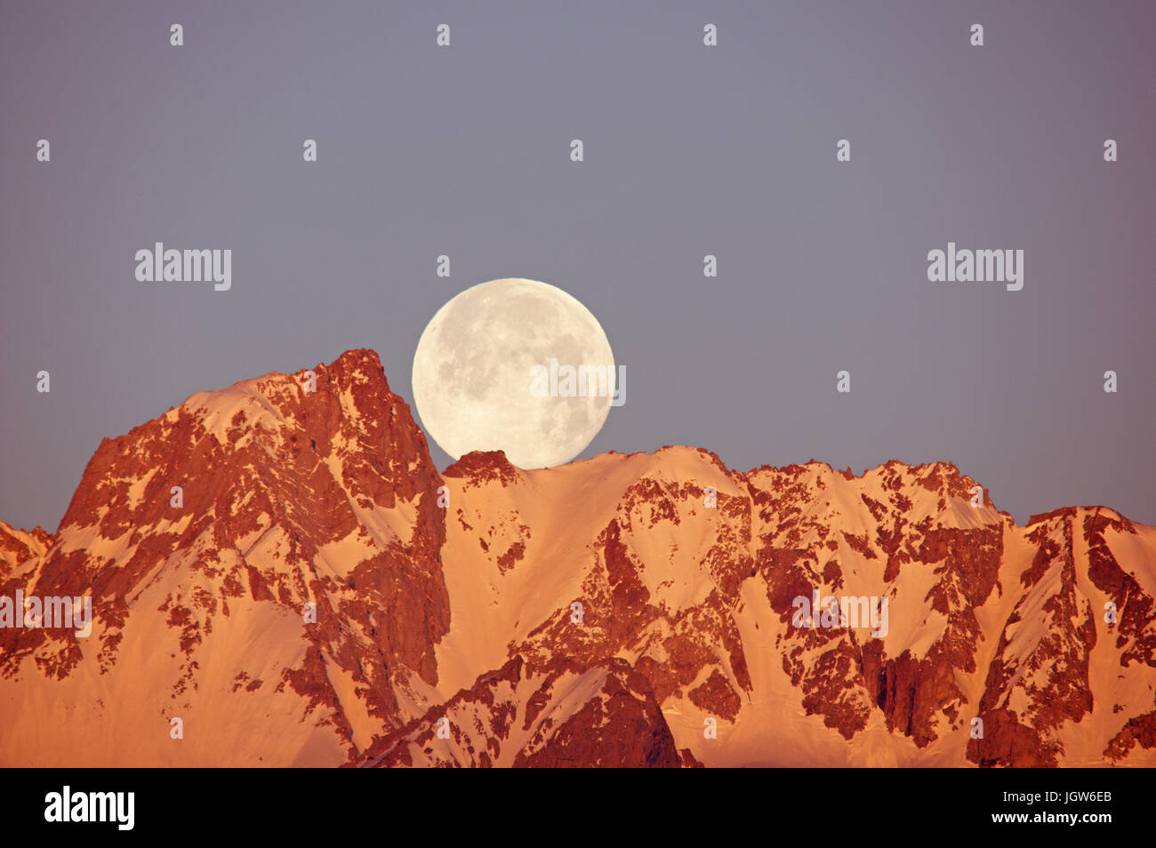 a full moon setting over Mount Humphreys mountain as the first light ...