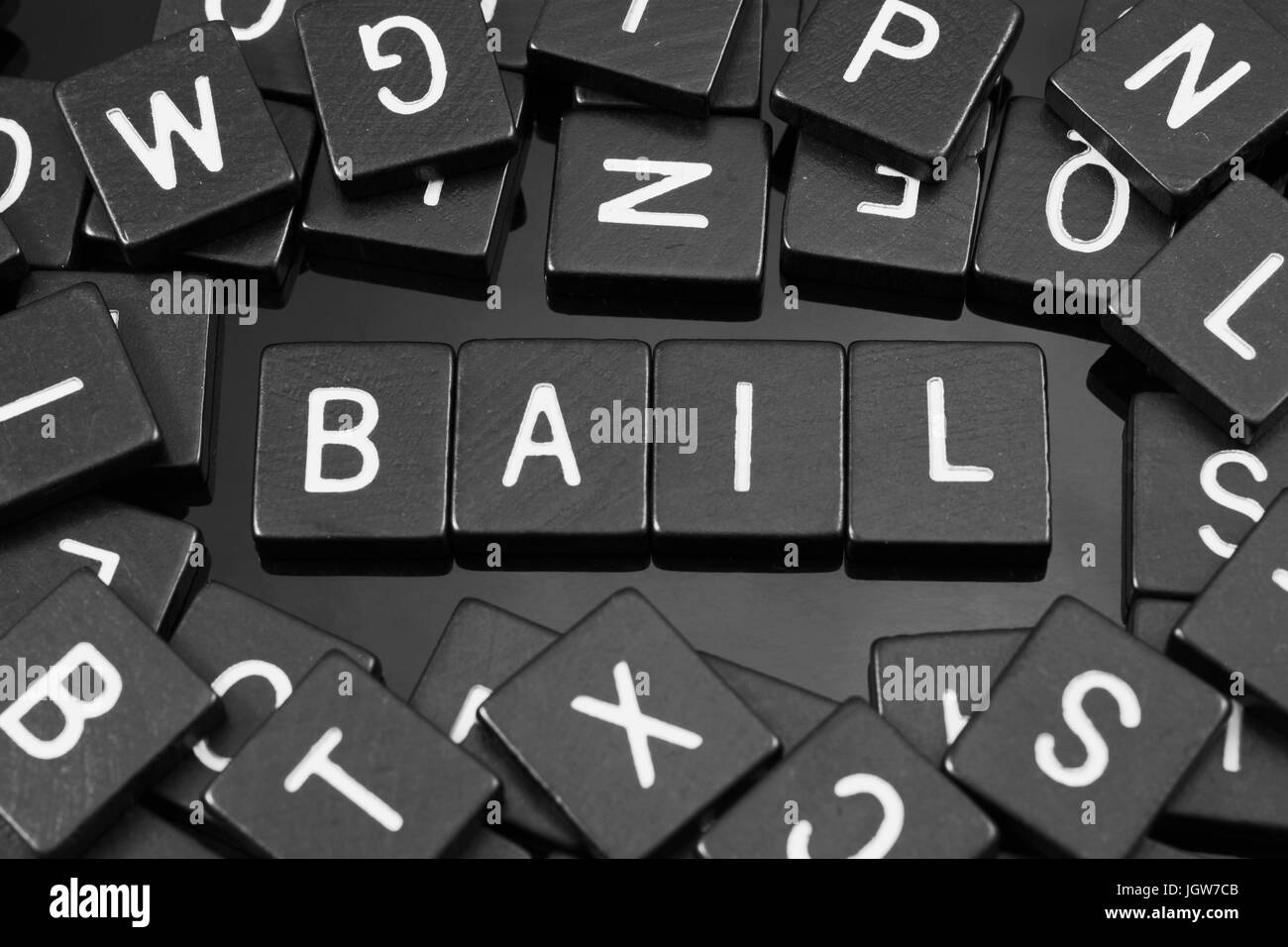 Black letter tiles spelling the word "bail" on a reflective background ...
