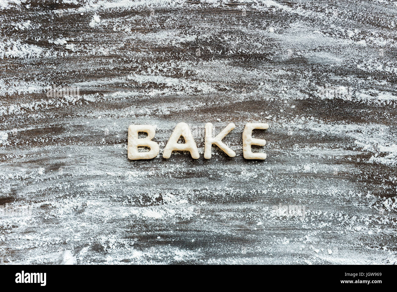 top view of word bake made from cookie dough with flour on wooden ...