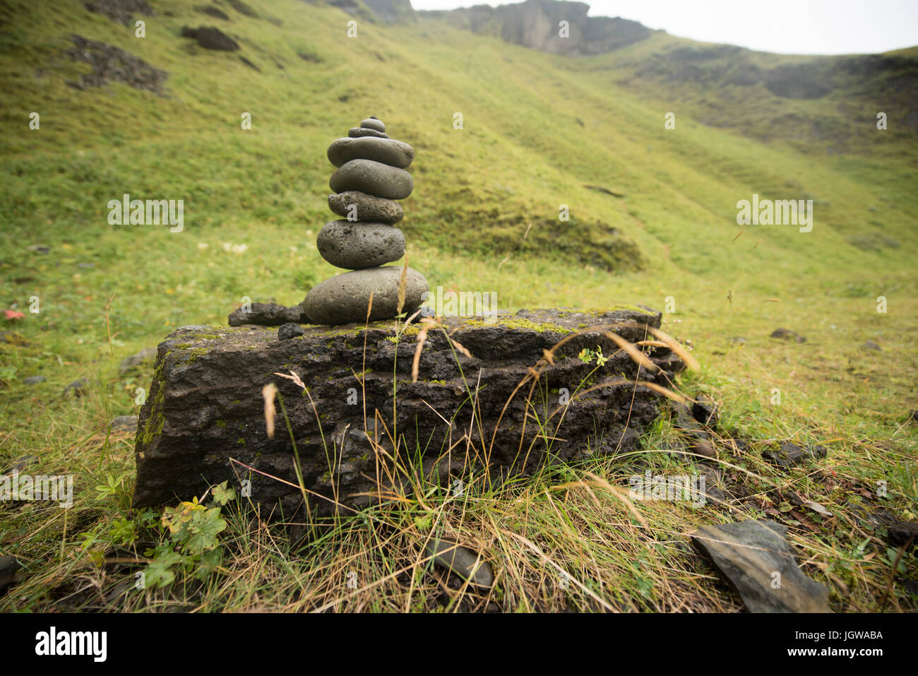 Stack of pebbles in a grass field Stock Photo - Alamy