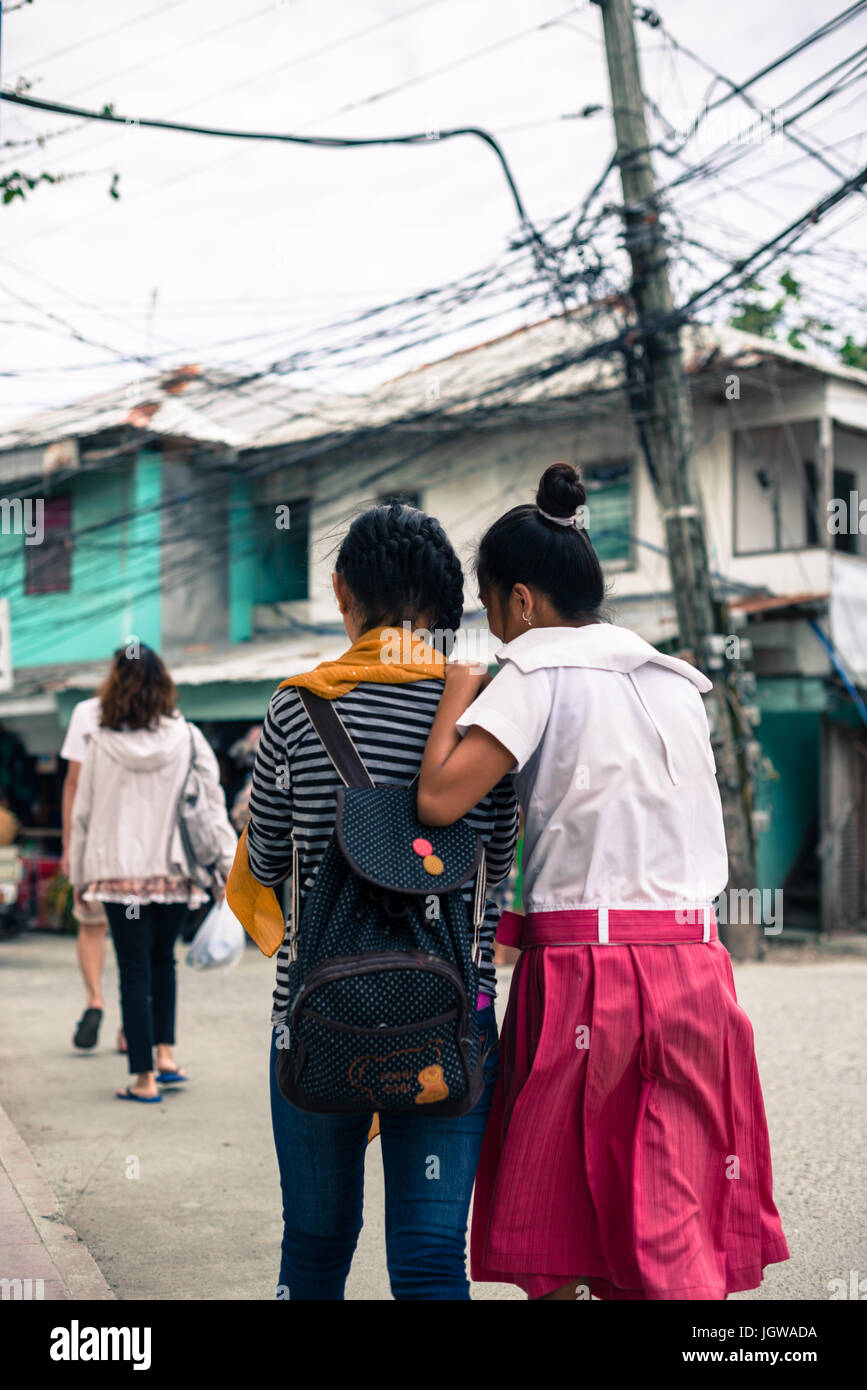 Two girl friends walking in a normal street of Boracay Stock Photo - Alamy