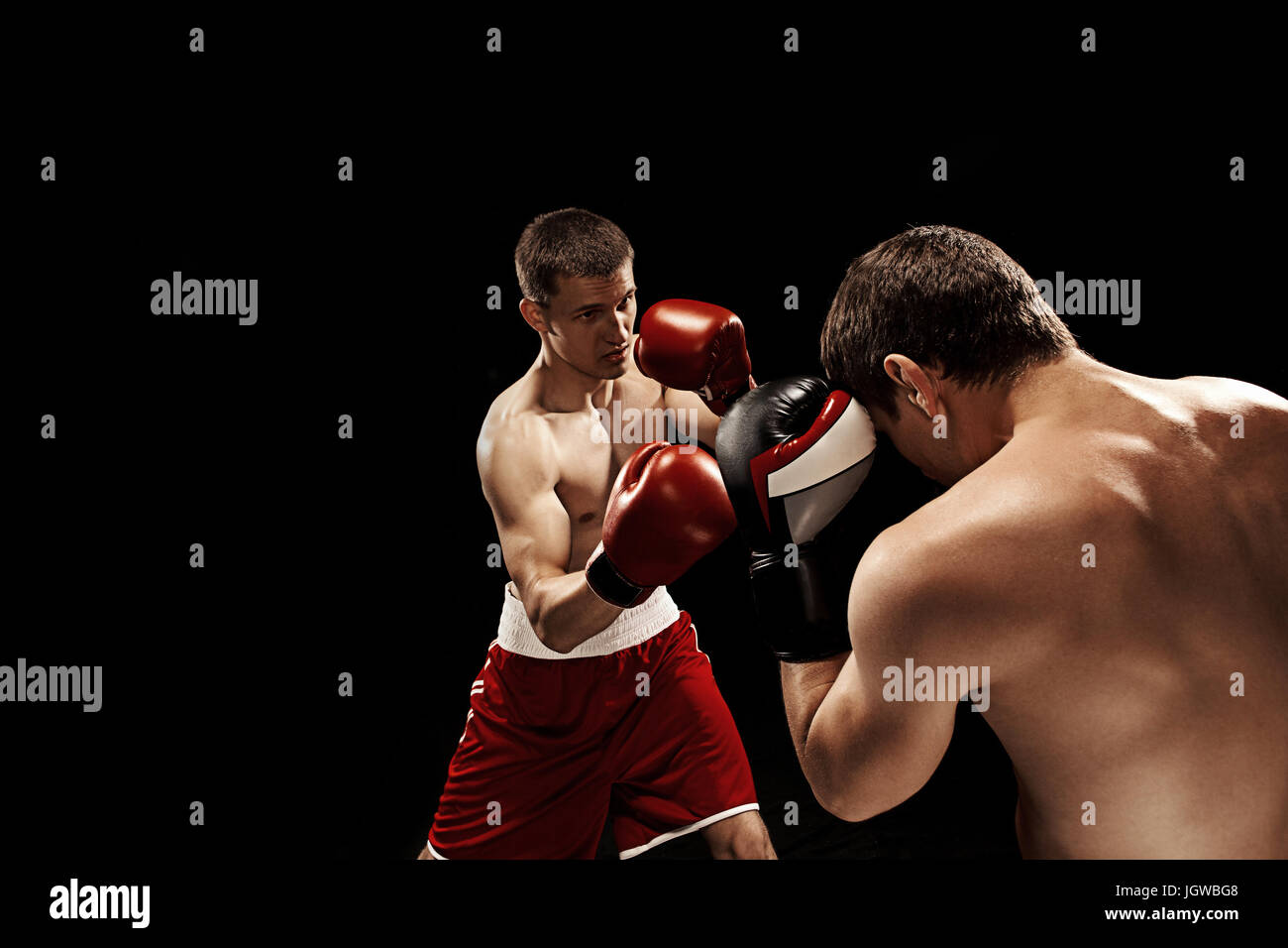 Two professional boxer boxing on black background Stock Photo - Alamy