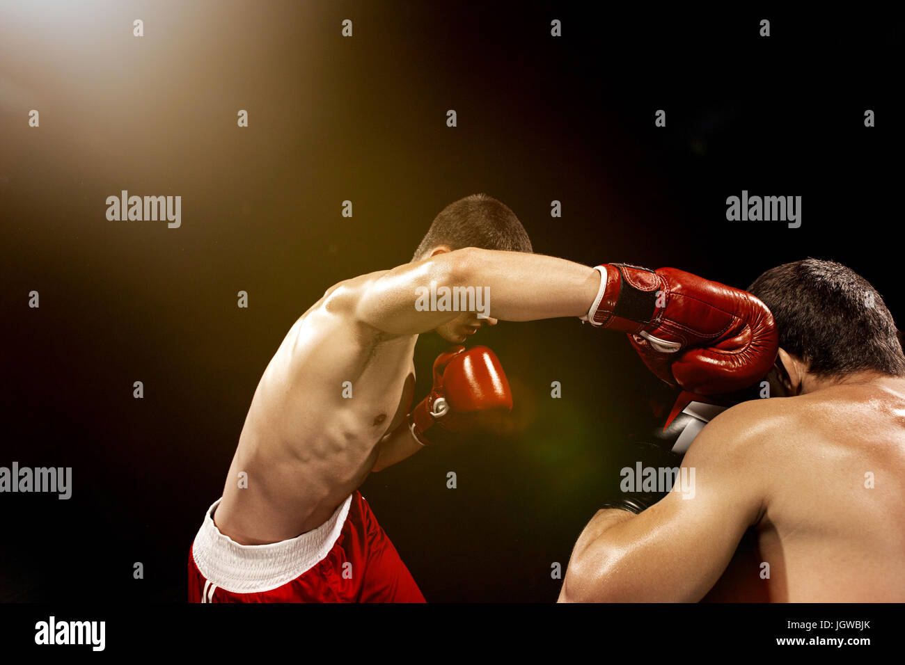 Two professional boxer boxing on black background Stock Photo - Alamy