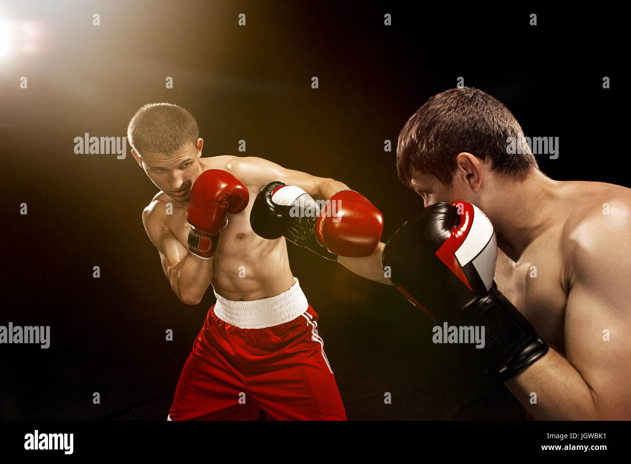 Two professional boxer boxing on black background Stock Photo - Alamy