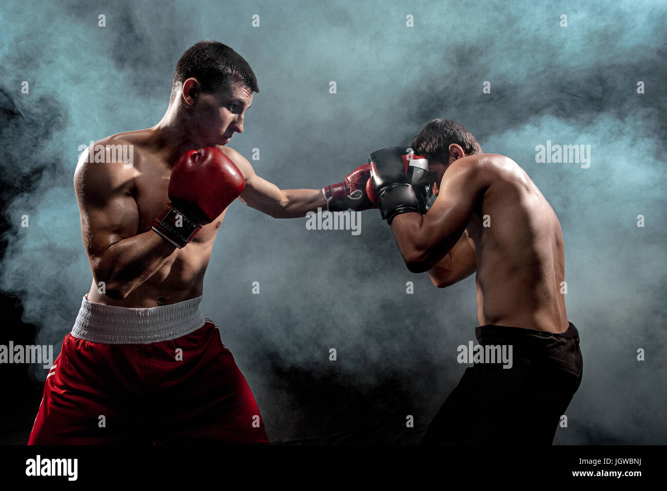 Two professional boxer boxing on black smoky background Stock Photo - Alamy