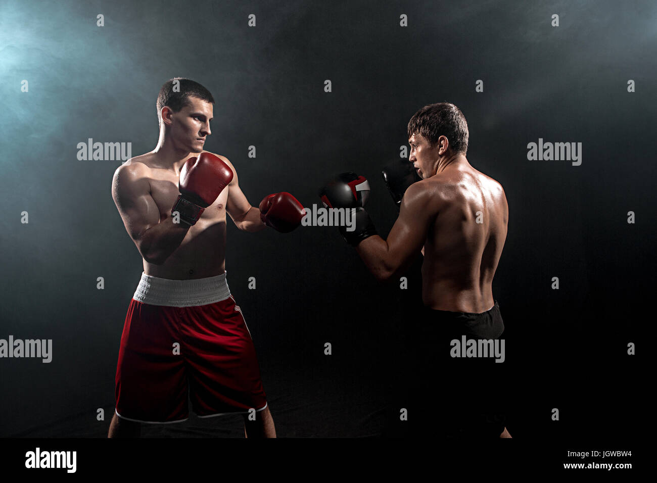 Two professional boxer boxing on black smoky background Stock Photo - Alamy