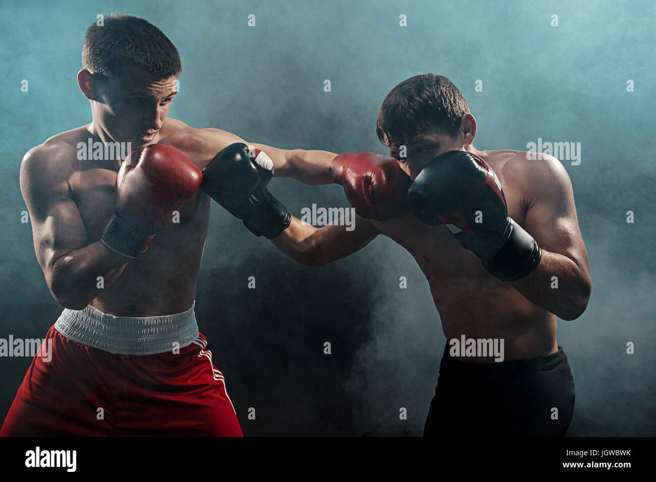 Two professional boxer boxing on black smoky background Stock Photo - Alamy