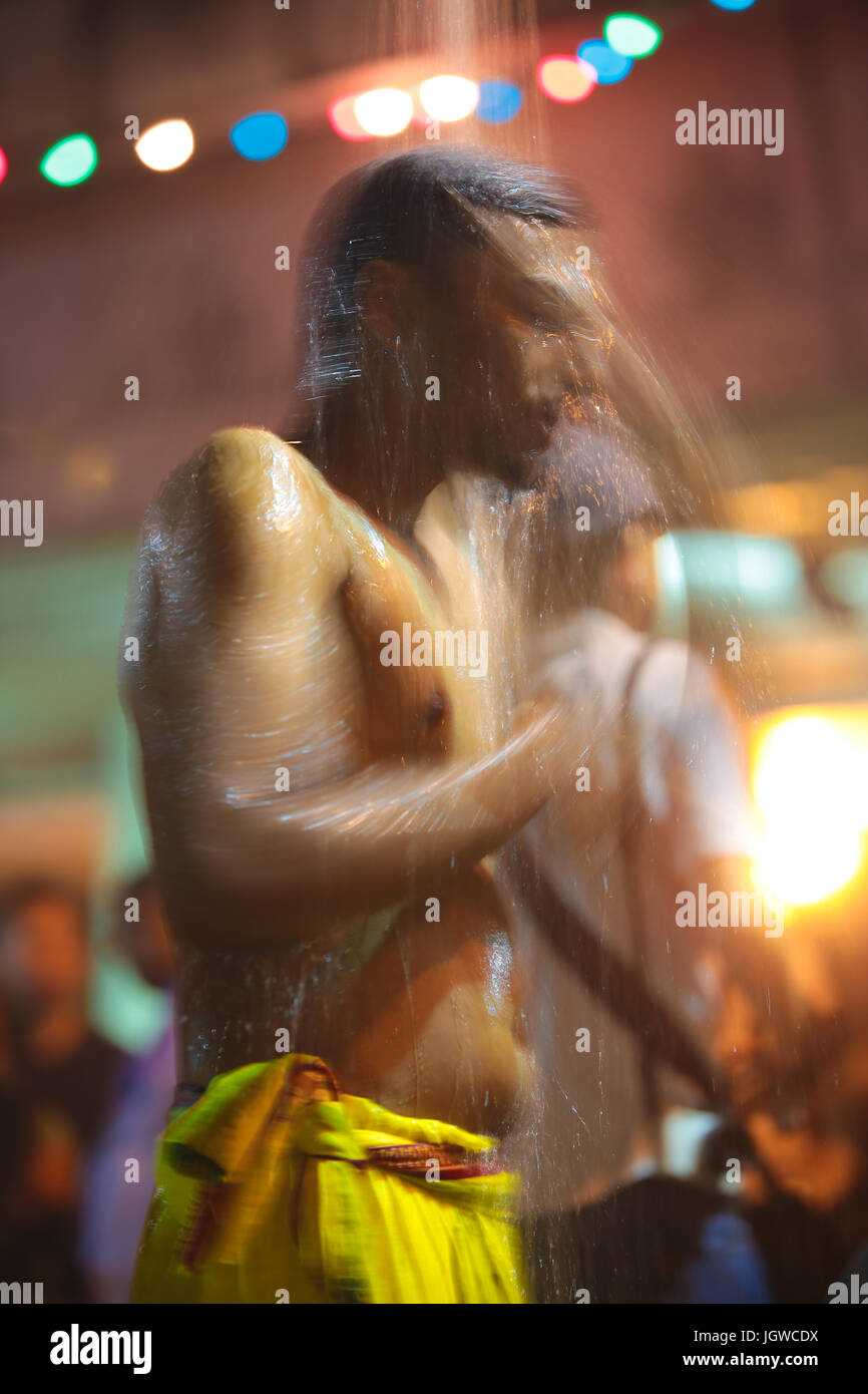 Hindu pilgrim taking shower before his kavadi walk to batu cave temple ...