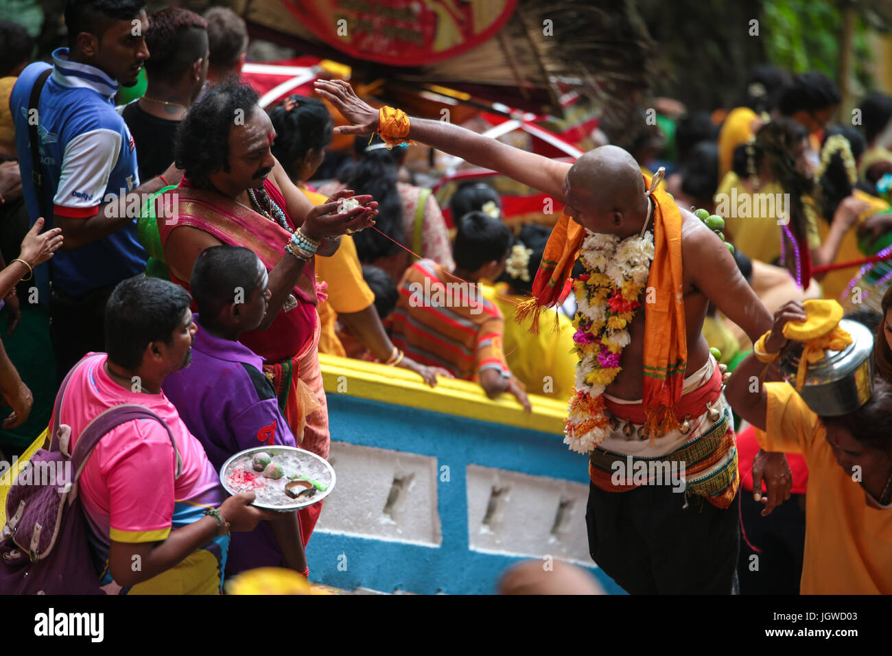 Hindu pilgrim giving blessing to a offering visitor at the batu cave ...