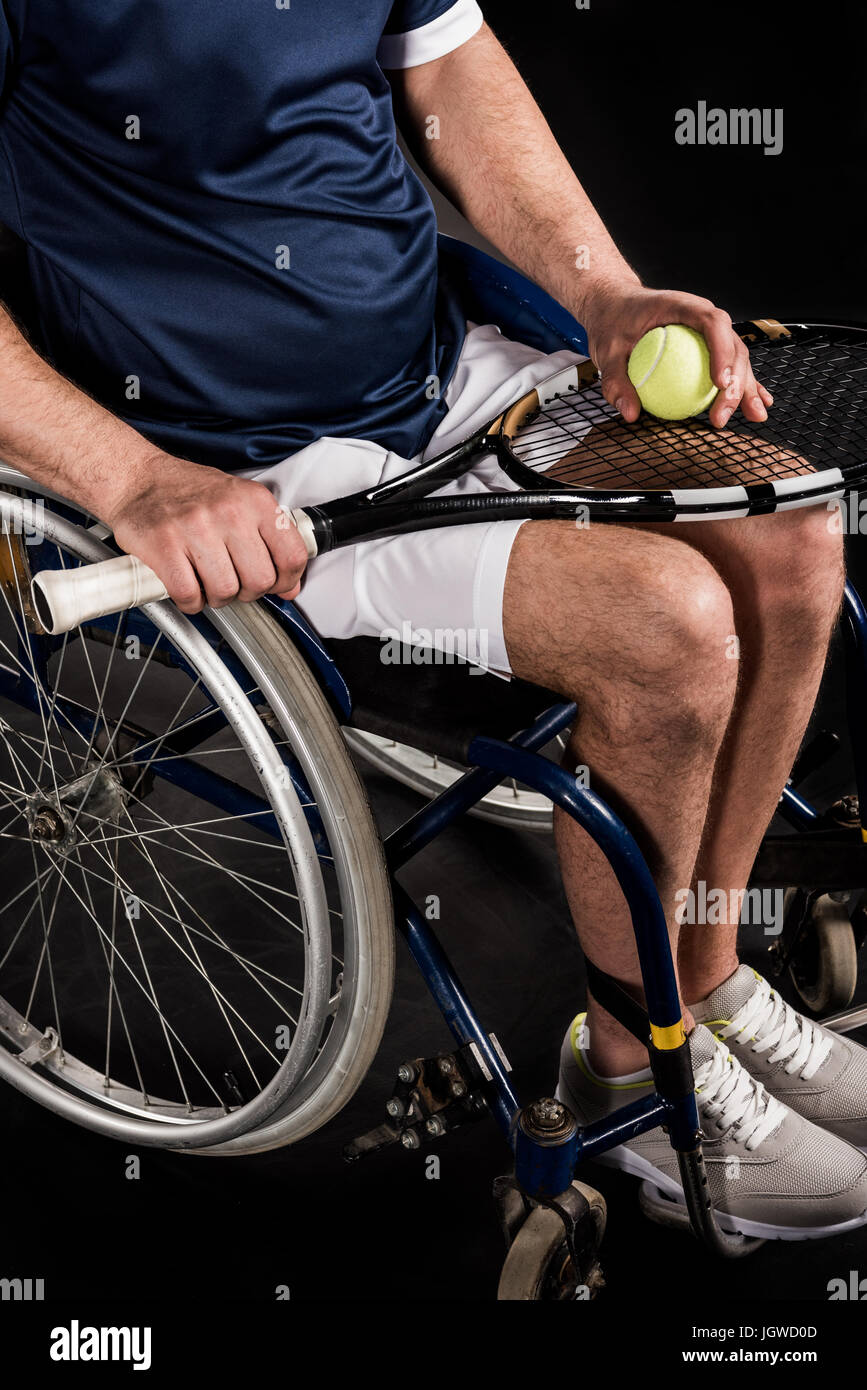 Cropped shot of disabled sportsman sitting in wheelchair and holding ...