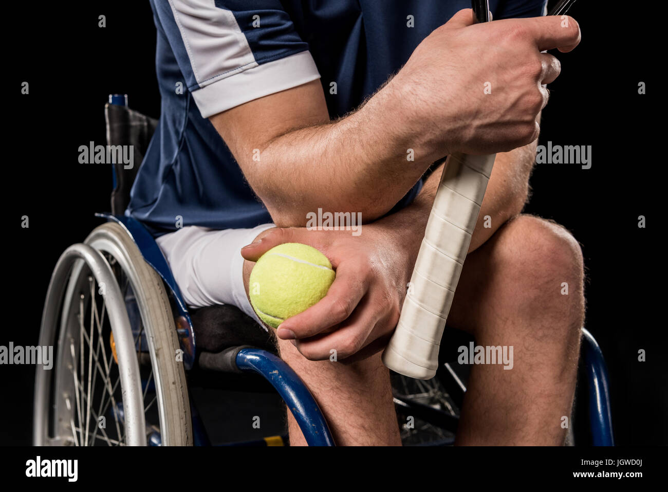 Cropped shot of disabled sportsman sitting in wheelchair and holding ...