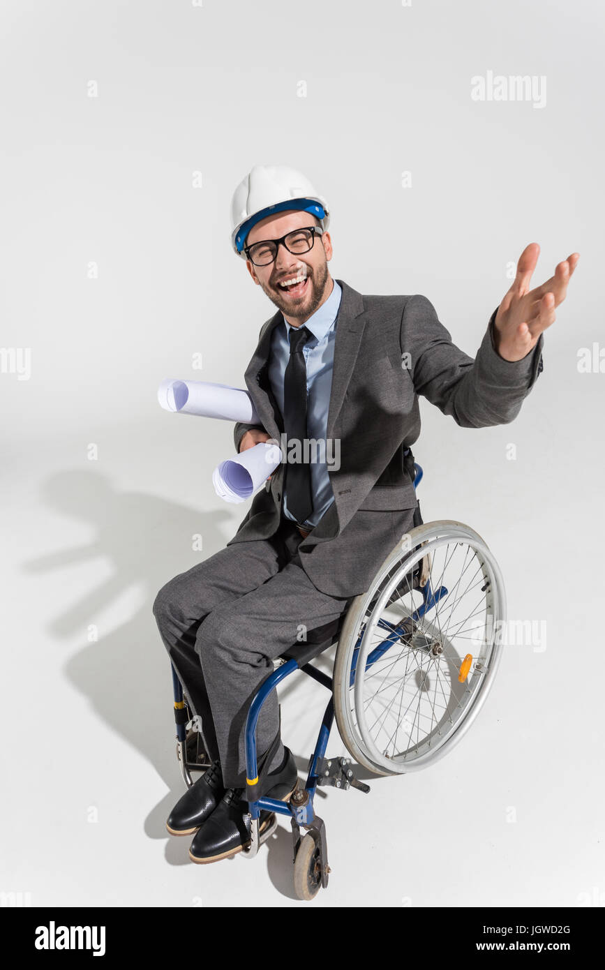 happy disabled architect in wheelchair with blueprints isolated on ...