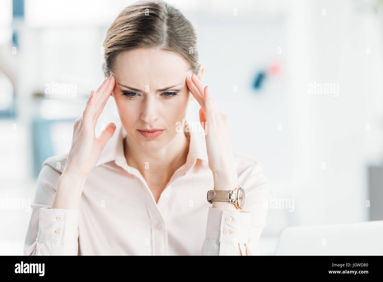 portrait of tired pensive businesswoman with hands on head looking down ...