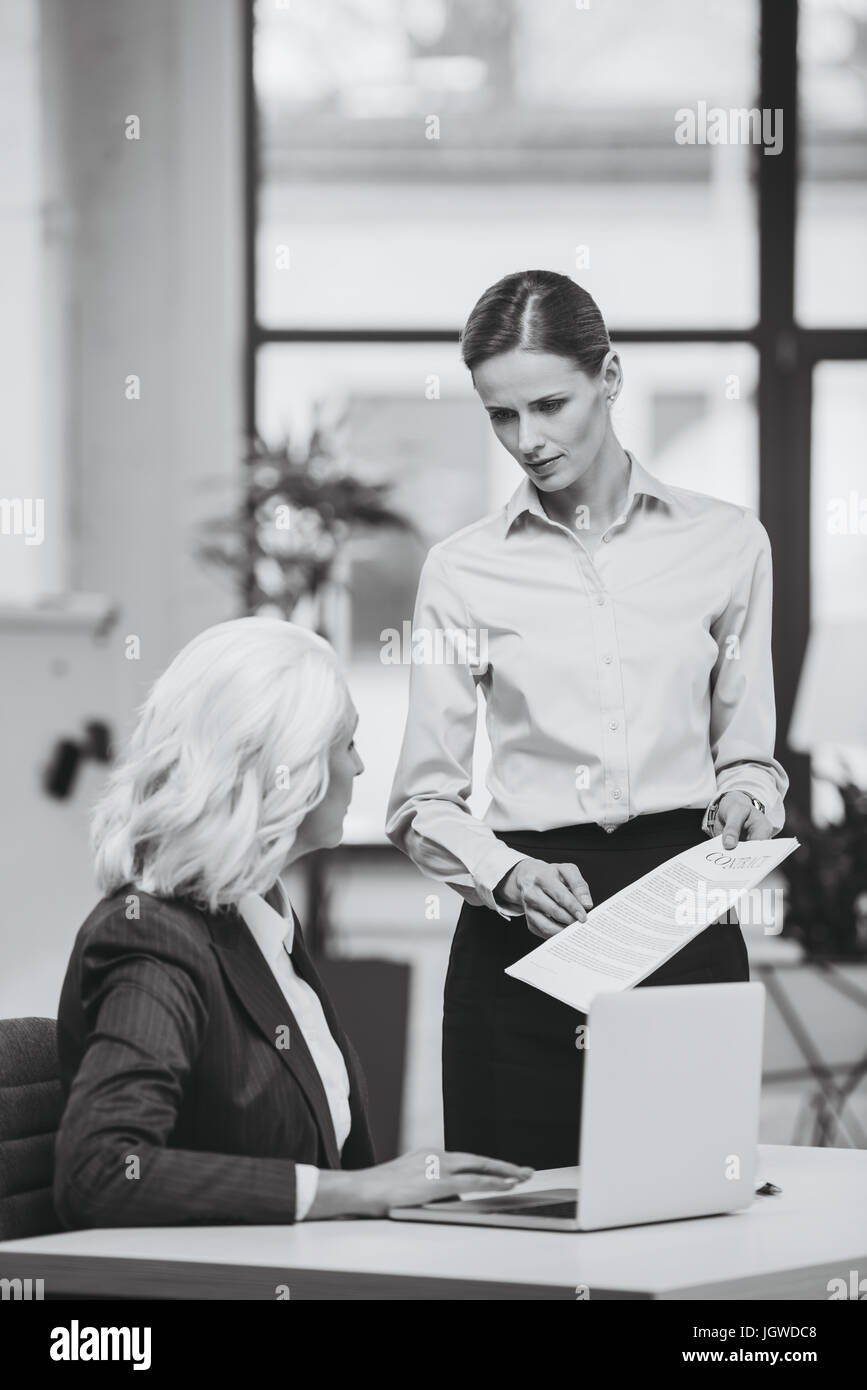 businesswoman and her boss working with documents in office, black and ...