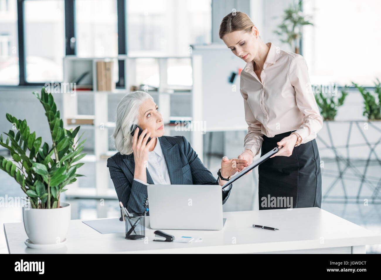 young businesswoman and her boss working with laptop computer and ...